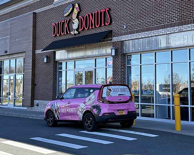 That cheerful duck mascot and bright pink delivery car make getting your donut fix feel like a party on wheels.