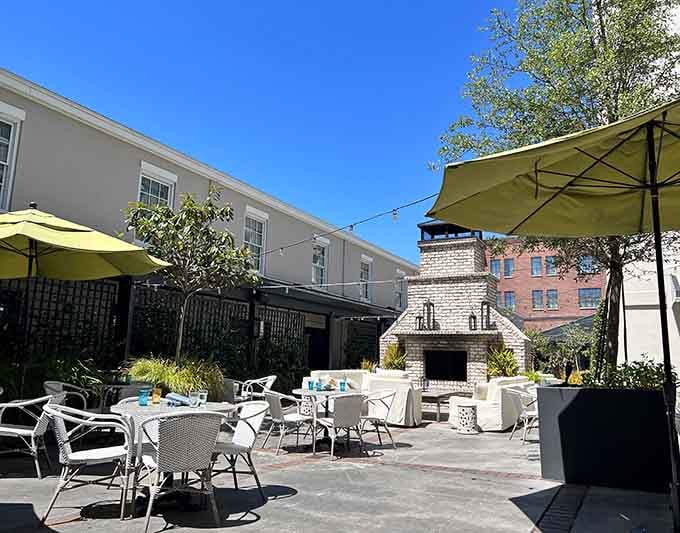 This modern courtyard features a stone fireplace and bright umbrellas creating the perfect blend of comfort and contemporary style.