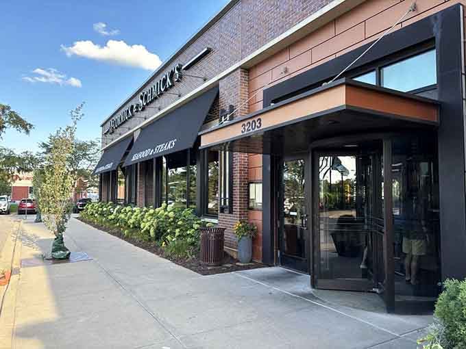 Elegant black awnings and manicured landscaping signal upscale dining where fresh catches meet classic steakhouse sophistication and style.
