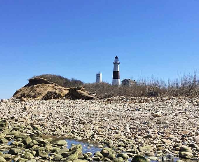 The rocky beach reveals its treasures when the tide retreats, leading your eye to that postcard-perfect maritime sentinel.