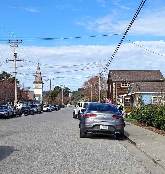 The church steeple rises in the distance, anchoring this peaceful street where time seems to move backward.