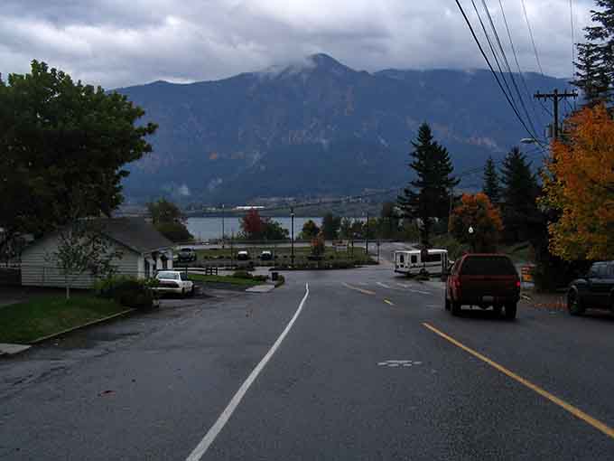 Moody skies and mountain peaks frame this quiet street where nature provides the most dramatic backdrop imaginable.