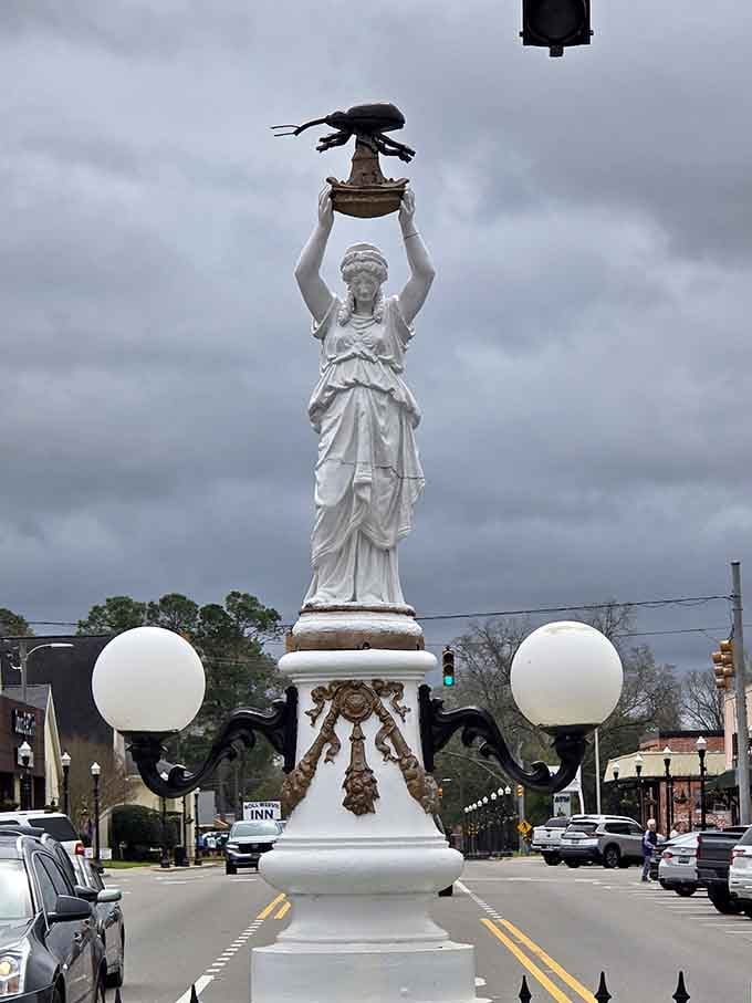 Look closer at that bronze boll weevil she's raising triumphantly, celebrating the pest that changed everything.