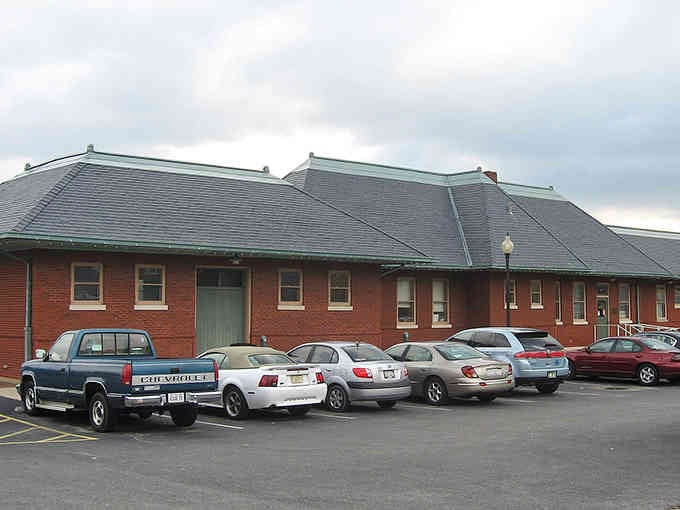 Classic brick architecture meets modern parking lots in this perfectly practical Midwestern tableau of everyday life.