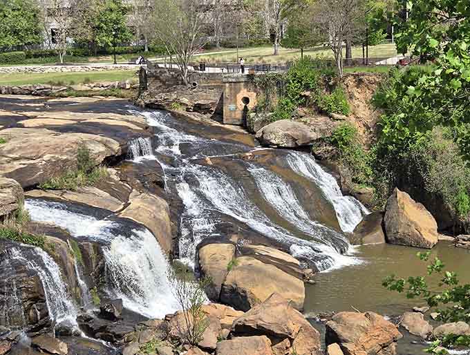 Multiple cascades tumble over layered rocks, creating a symphony of rushing water right in the heart of downtown.