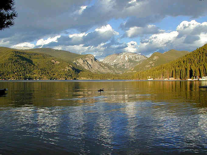 One lone duck gliding across mirror-still water while snow-capped peaks stand guard&mdash;this is Colorado's quiet side at its finest.