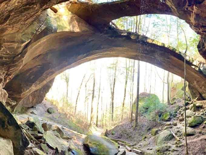 Sunlight streams through massive rock openings, illuminating a geological masterpiece millions of years in the making.