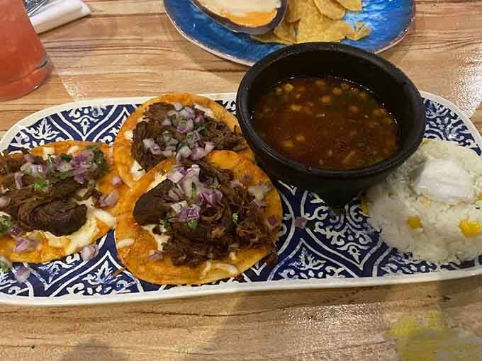 Tender meat, fresh onions, and that gorgeous patterned plate make these tacos look like edible art.