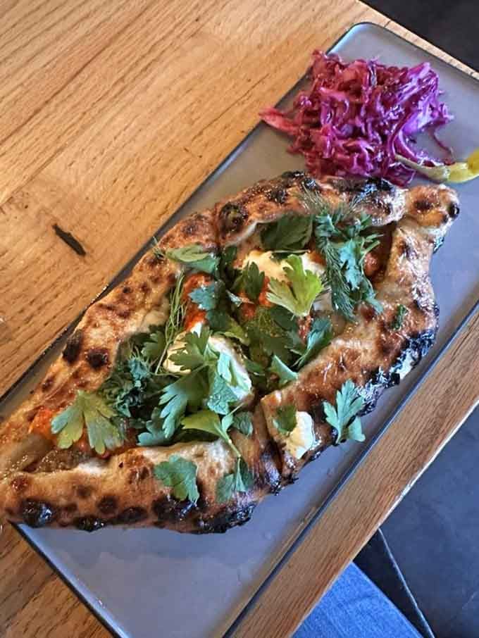 The beef pide arrives looking like a work of art, with fresh herbs cascading over golden flatbread that's begging to be devoured.