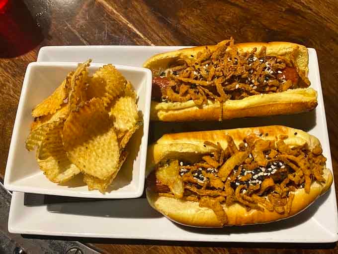 These loaded hot dogs come topped with crispy onions, proving comfort food doesn't need a controller.