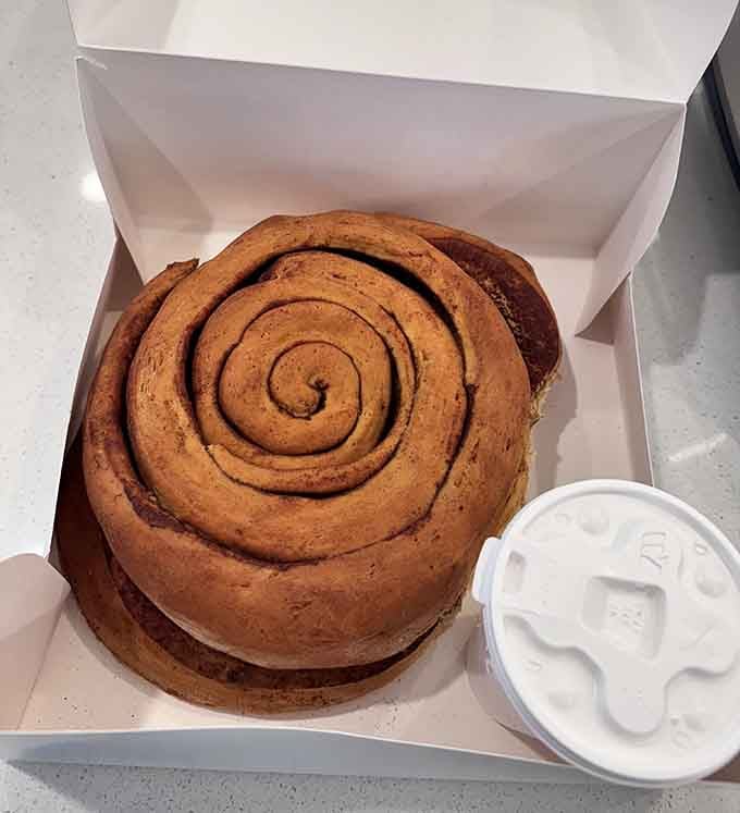 Behold: a cinnamon roll so magnificent it comes with its own container of icing for structural support.