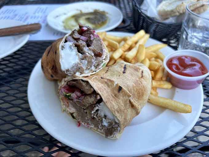 The gyros sandwich arrives loaded with seasoned meat, wrapped in warm pita, and sided with crispy fries for good measure.