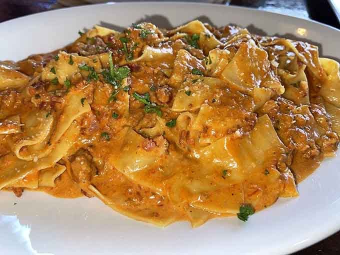 Pappardelle Bolognese arrives glistening with rich meat sauce, wide ribbons of pasta embracing every savory bite perfectly.