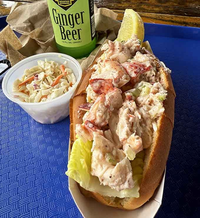 A lobster roll so generously stuffed it looks like the crustacean equivalent of winning the lottery, served waterside naturally.