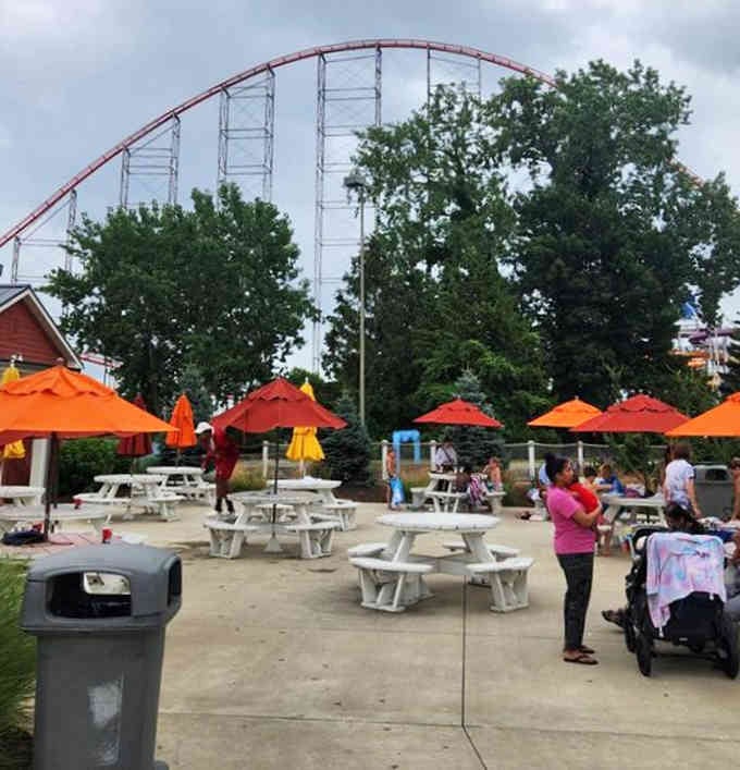 Outdoor seating with a roller coaster backdrop, because apparently eating lunch needs more adrenaline in Sandusky.