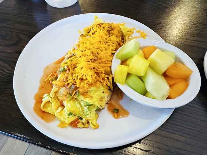 Golden eggs folded around fresh vegetables and melted cheese, topped with a glorious mountain of shredded cheddar.