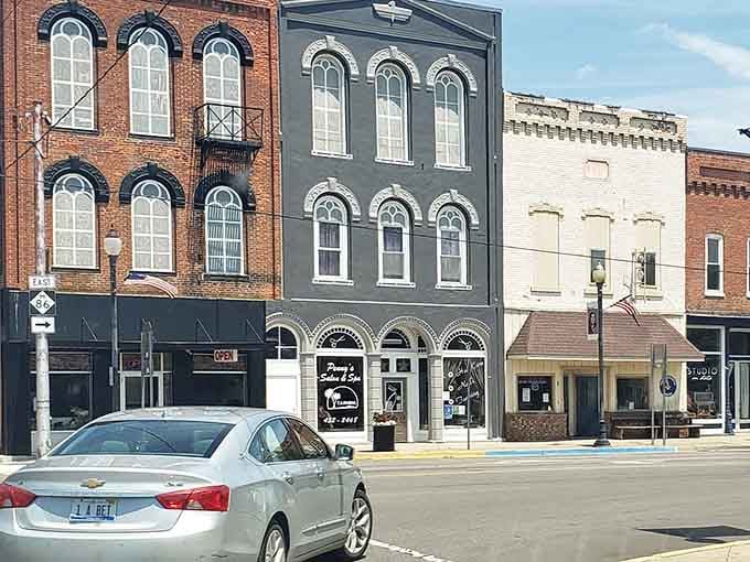 The painted facades and vintage storefronts create a streetscape that Instagram filters try desperately to replicate but never quite capture.