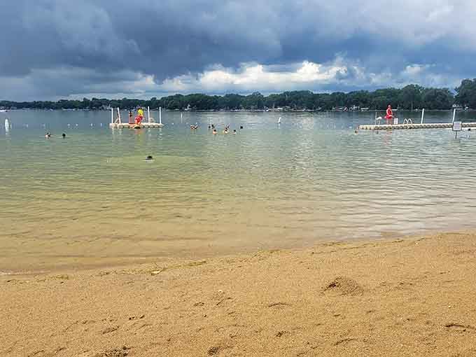 Storm clouds gather dramatically overhead while swimmers enjoy nature's free light show from the perfect vantage point.