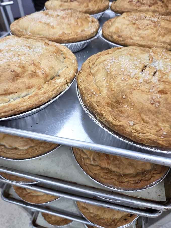 Fresh pot pies cooling on racks, their golden crusts glistening like edible treasure just waiting to happen.