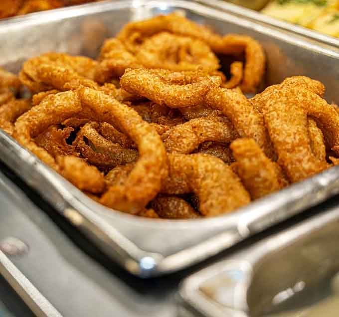 Golden onion rings piled high, proving that some classics never need improvement, just appreciation.