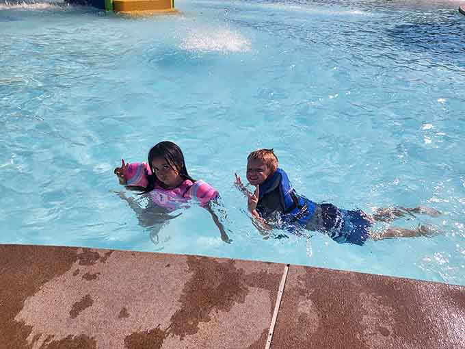 Pure joy captured in chlorinated water, these two are living their best lives with peace signs and smiles.