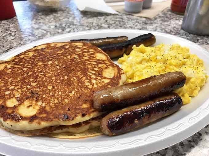 Golden pancakes, perfectly scrambled eggs, and sausage links that understand the assignment better than most people do.