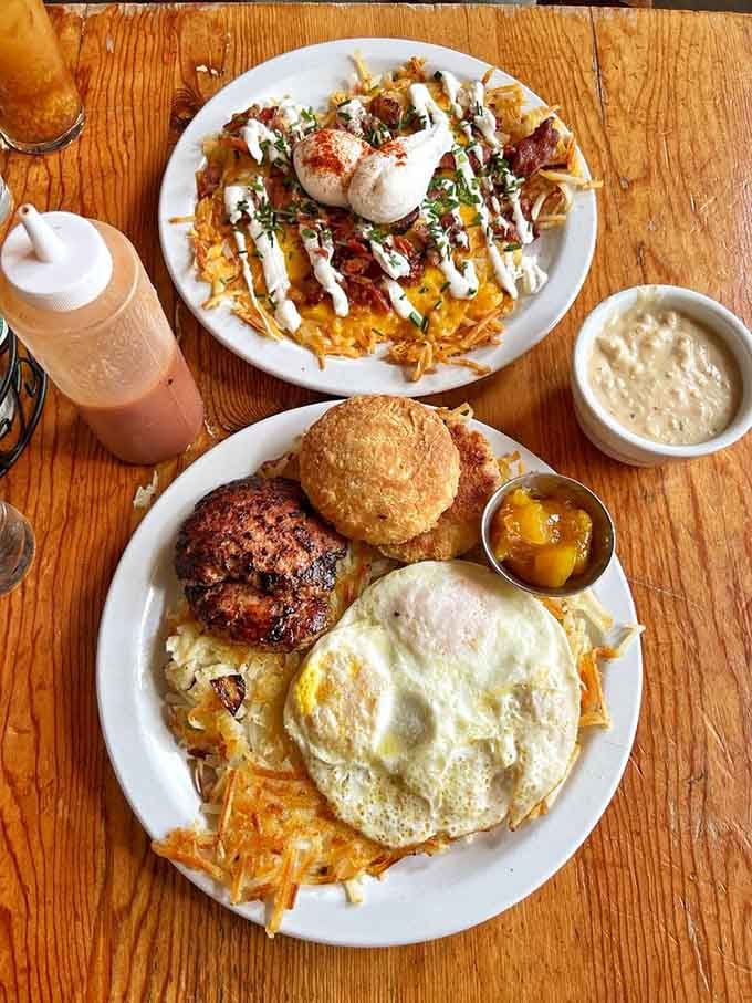 Biscuits, sausage, eggs, and hash browns arranged like edible architecture on plates built for serious appetites.