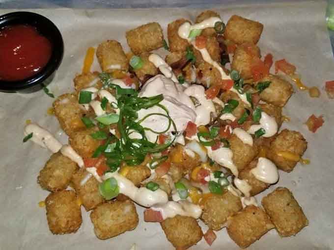 Loaded tots piled high with bacon, cheese, and enough toppings to require architectural support and zero regrets whatsoever.