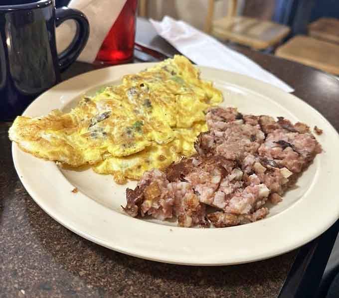 That golden omelet paired with corned beef hash is the kind of plate that makes alarm clocks worthwhile.