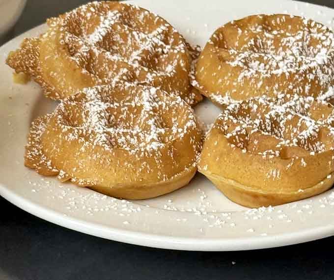 Belgian waffles never looked so delicious, dusted with powdered sugar and ready to make your inner child very happy.