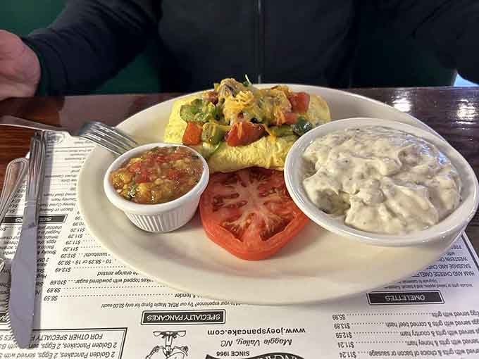 That omelet looks like it's auditioning for a cooking show, complete with perfectly placed garnishes and serious fluffy credentials.
