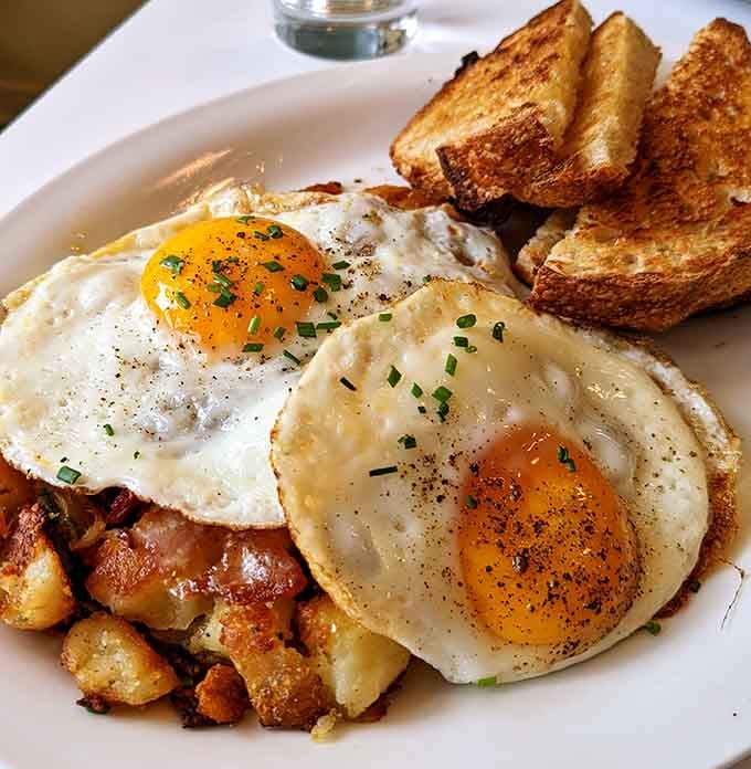 Two perfectly fried eggs perched atop crispy hash browns with golden toast, this is what breakfast dreams are made of.