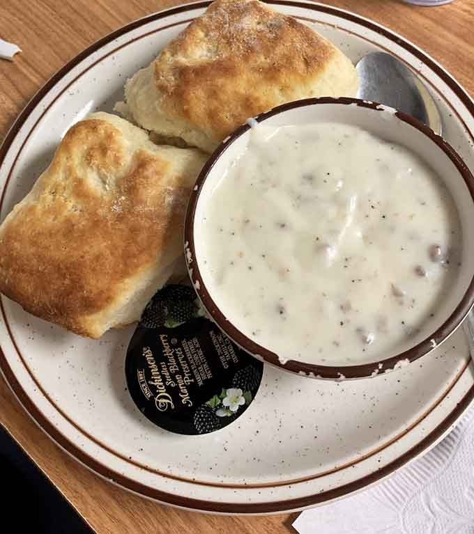 Two golden biscuits meet their creamy, peppery destiny in a bowl of sausage gravy that'll ruin you for life.