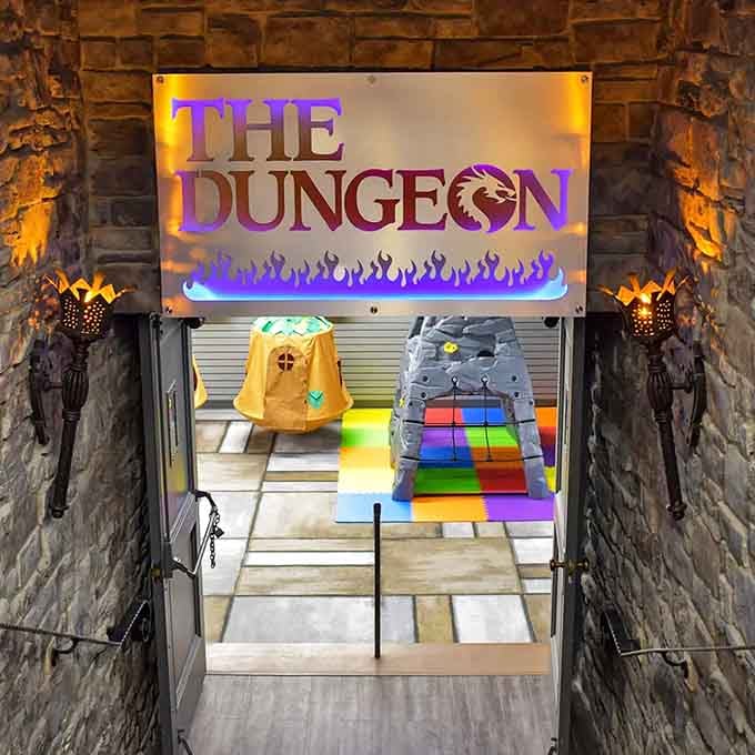 The Dungeon beckons with torches and mystery, proving even dragons need a proper playroom entrance these days.