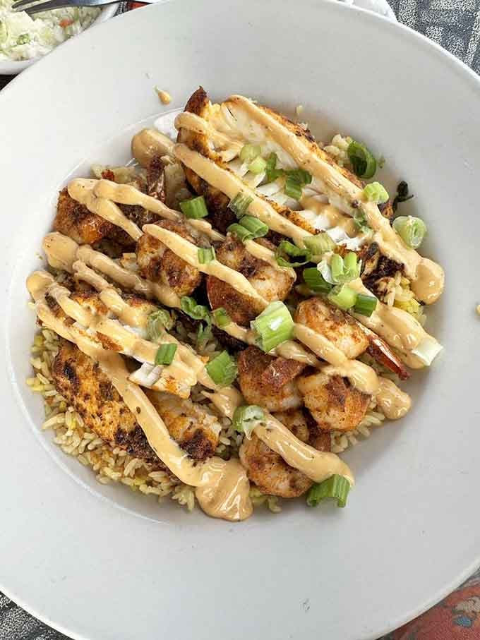 Blackened perfection over rice with that creamy drizzle and fresh scallions makes landlocked dining feel absolutely coastal.