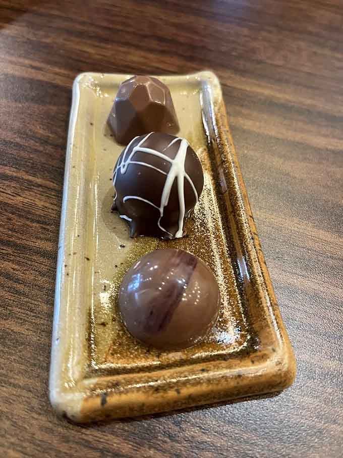 Three perfect bonbons on a golden tray &ndash; because sometimes presentation matters almost as much as the chocolate itself.