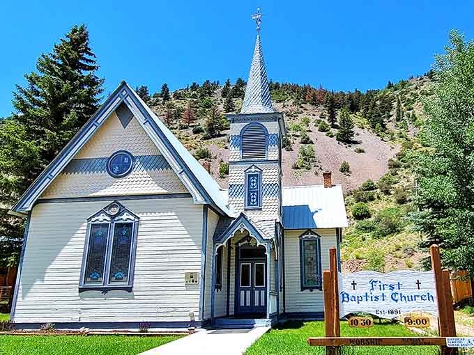 The First Baptist Church stands white and proud, its steeple reaching skyward like it's trying to get better cell reception.