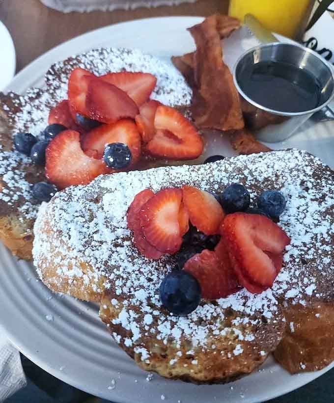 French toast dusted with powdered sugar and crowned with fresh berries, because sometimes breakfast needs to look this photogenic.