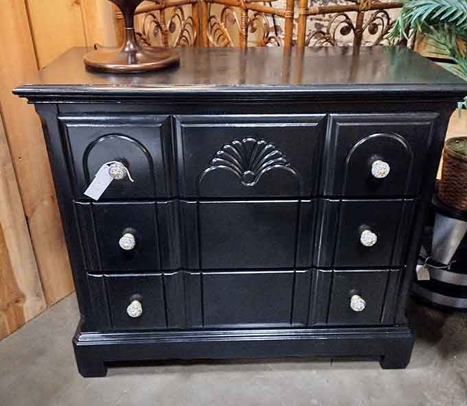 This glossy black cabinet with ornate details proves that sometimes the best furniture has already lived a full life.