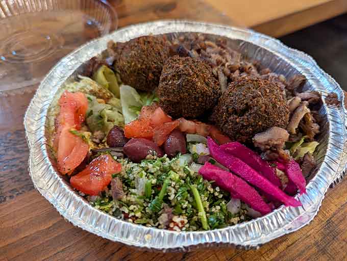 Golden falafel balls nestled among vibrant veggies and olives, this plate is basically edible art with serious flavor.