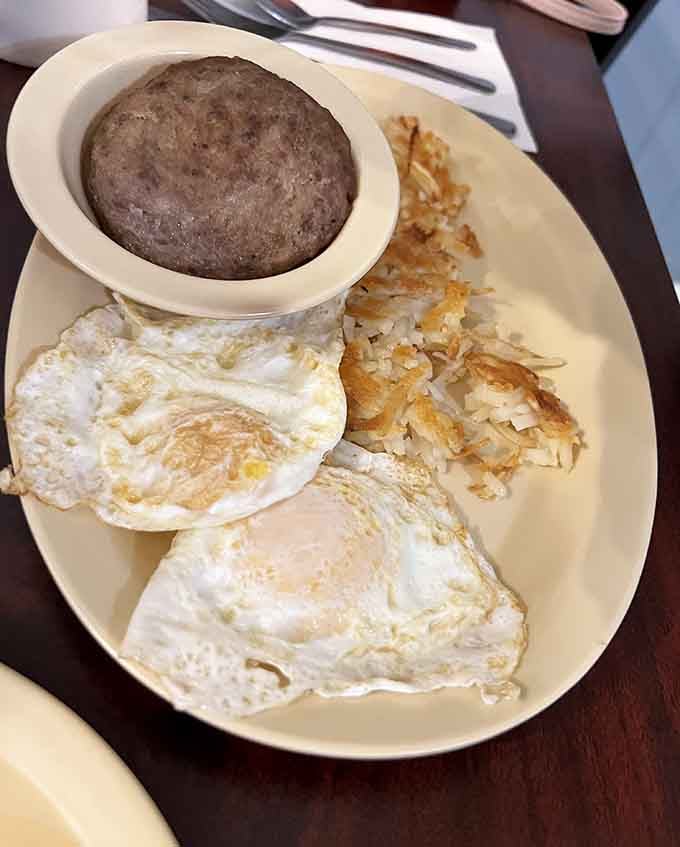 Two perfectly cooked eggs, crispy hash browns, and grits that understand their assignment on one glorious plate.