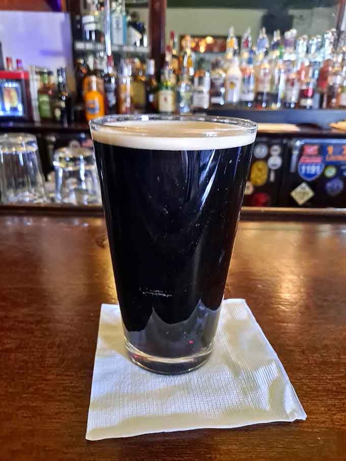 A perfectly poured Guinness sits ready at the bar, dark as midnight and twice as mysterious in this haunted haven.