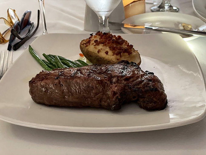 That perfectly seared strip steak with its loaded baked potato proves simple done right beats complicated done wrong.