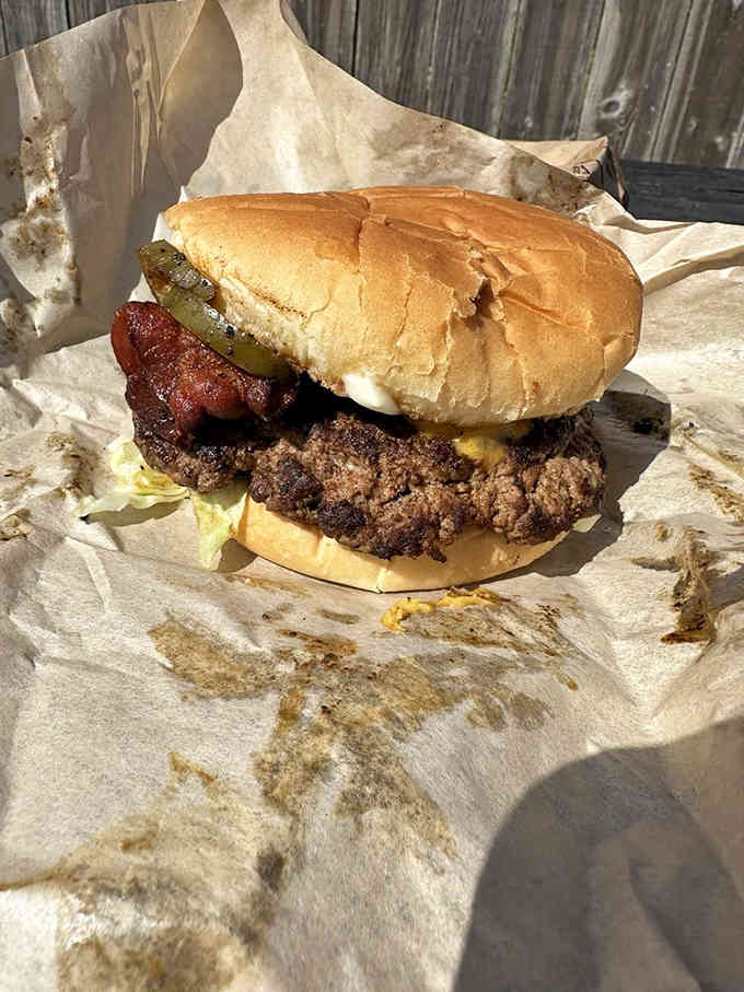 Behold the perfectly griddled patty with crispy bacon and pickles, wrapped in paper like a delicious present you give yourself.