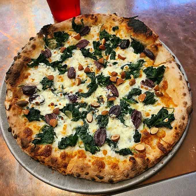 The Xerxes pizza proves that sometimes the best relationships involve cheese, greens, and a little char.