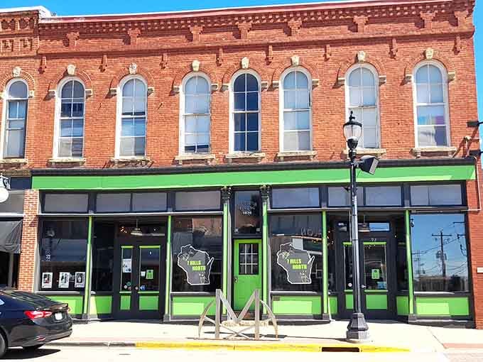 This storefront's green trim pops against red brick like a Christmas card that decided to stick around all year long.
