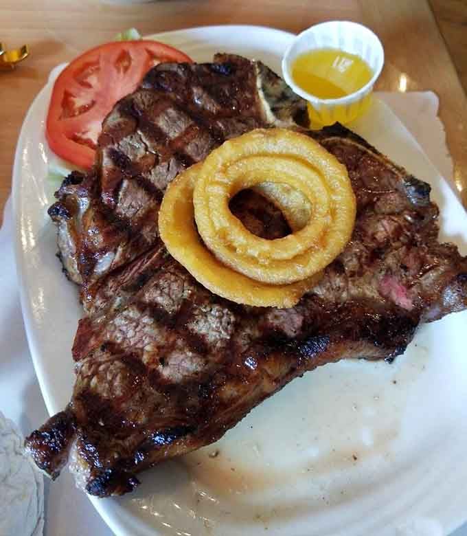 This porterhouse arrives like it's auditioning for a steakhouse hall of fame, complete with its own onion ring crown.