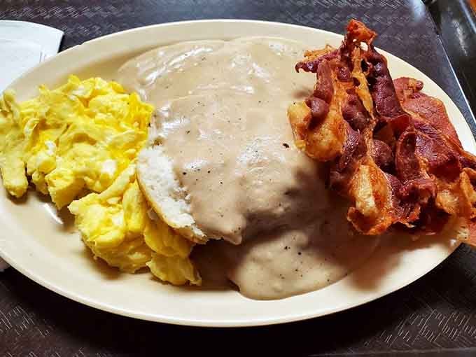 Biscuits drowning in sausage gravy with crispy bacon: this is what mornings were invented for, folks.