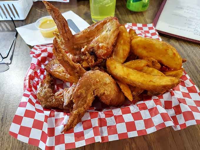Golden wings and crispy wedges arrive like edible treasure, proving simple done right beats fancy every time.