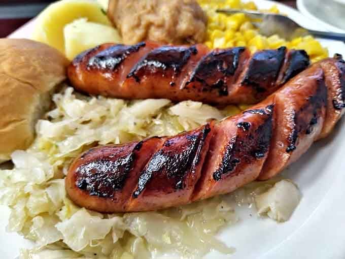 Grilled kielbasa resting on a bed of cabbage like it's posing for its own cooking show debut.